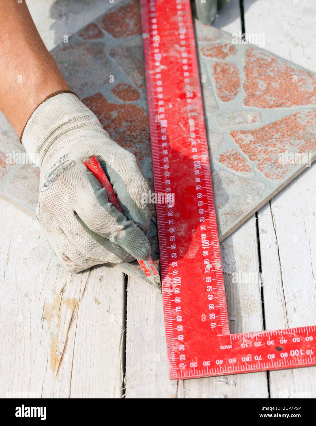 Man measuring a tile piece with a pencil Stock Photo - Alamy