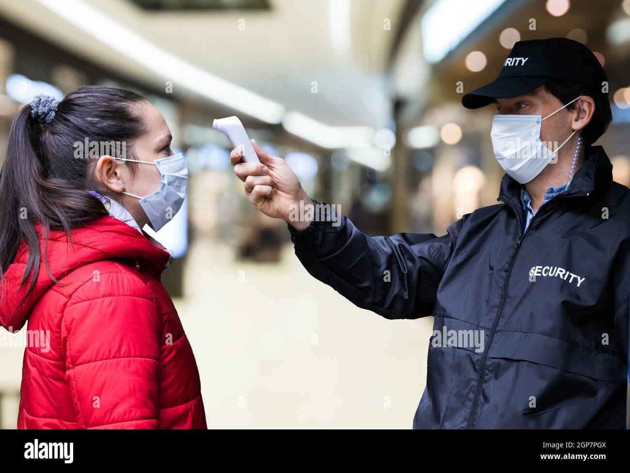 Security Guard Temperature Scan At Shopping Mall Stock Photo - Alamy