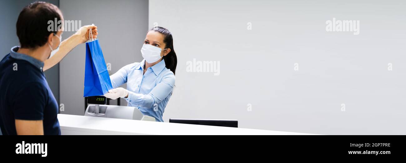 Cashier In Retail Shop Or Store At Counter Wearing Face Mask Stock ...