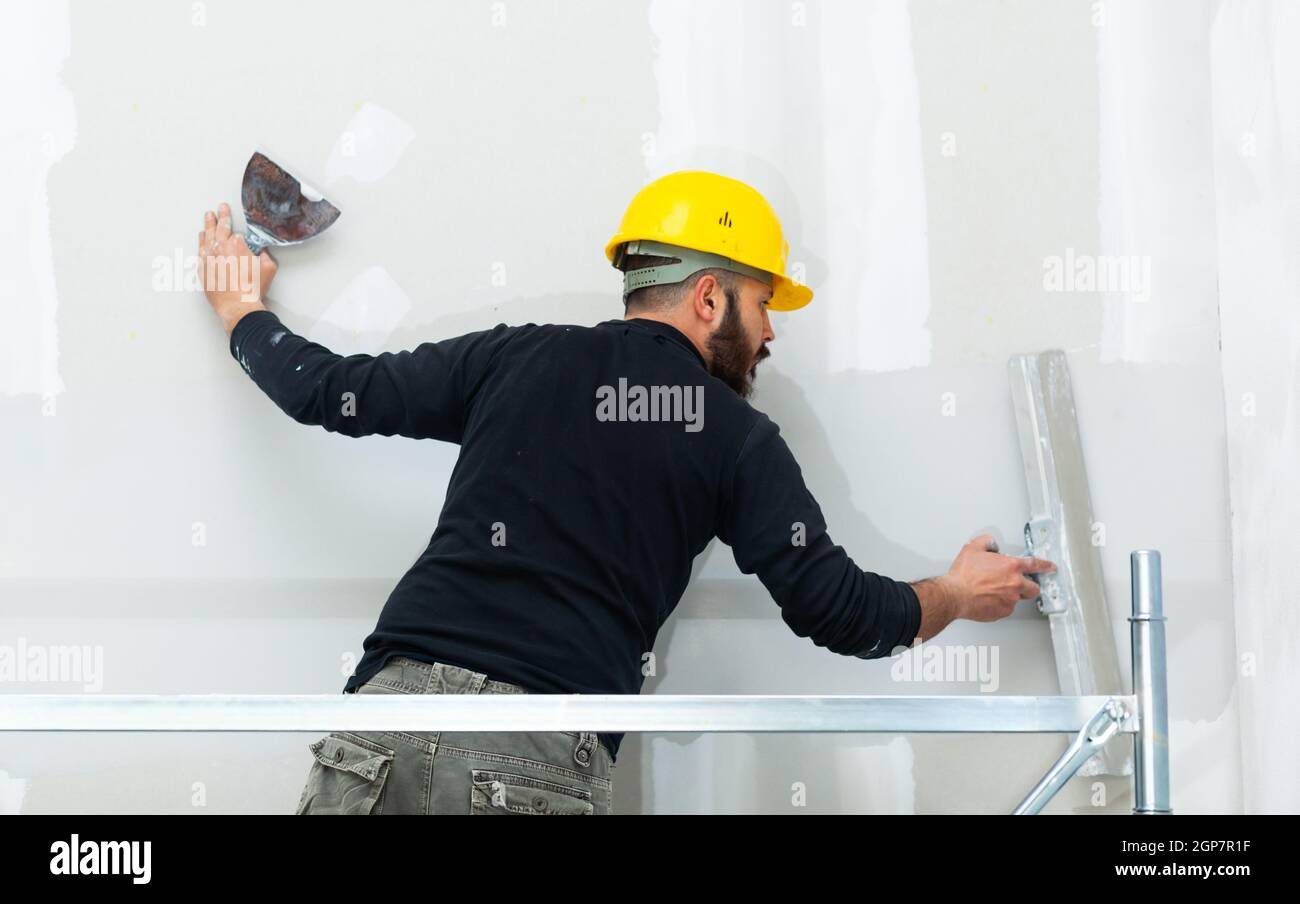 Interior construction, worker plastering gypsum board wall Stock Photo ...