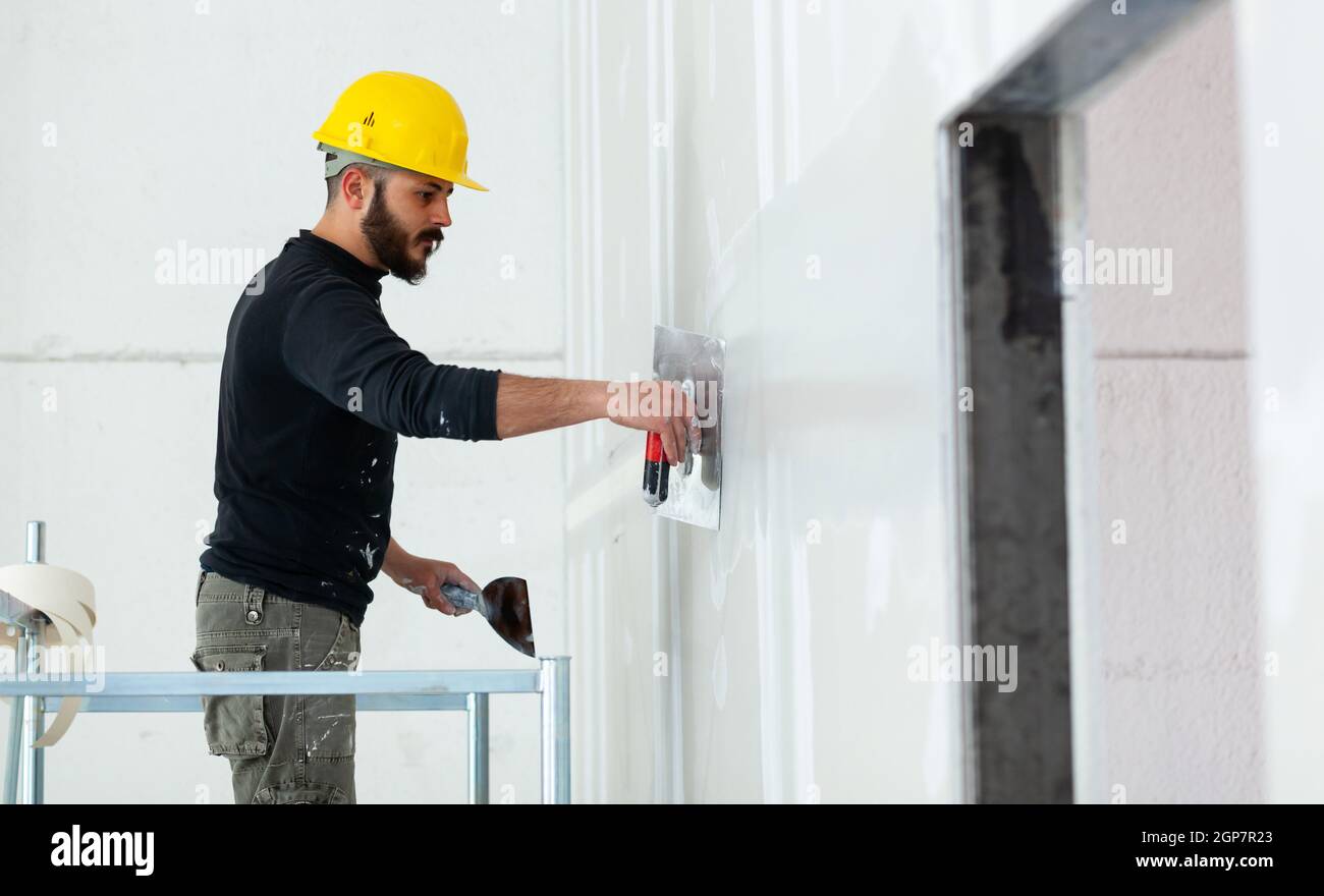 Interior construction, worker plastering gypsum board wall Stock Photo ...