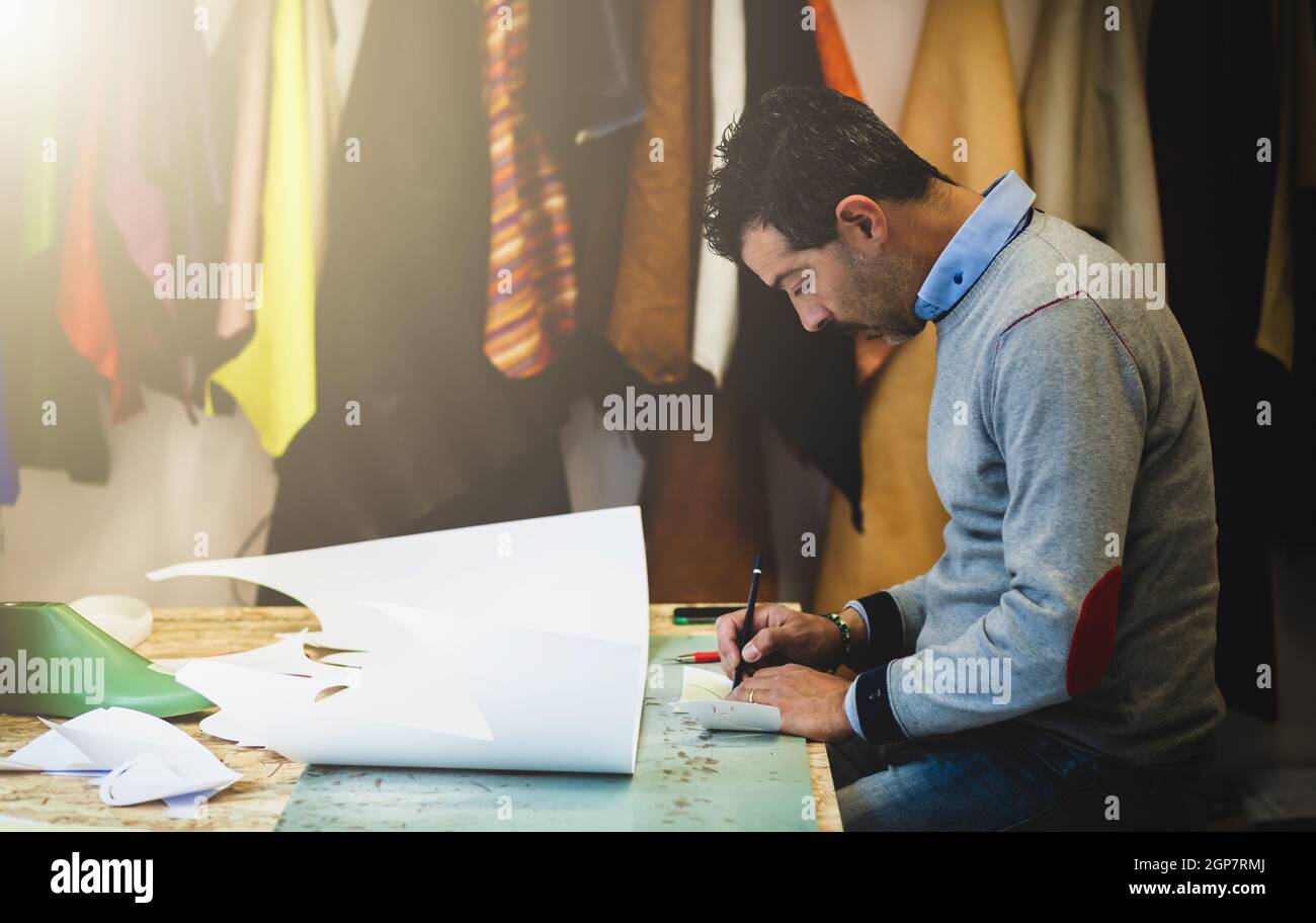 Shoemaker or shoe designer working with lwith paper models for leather ...