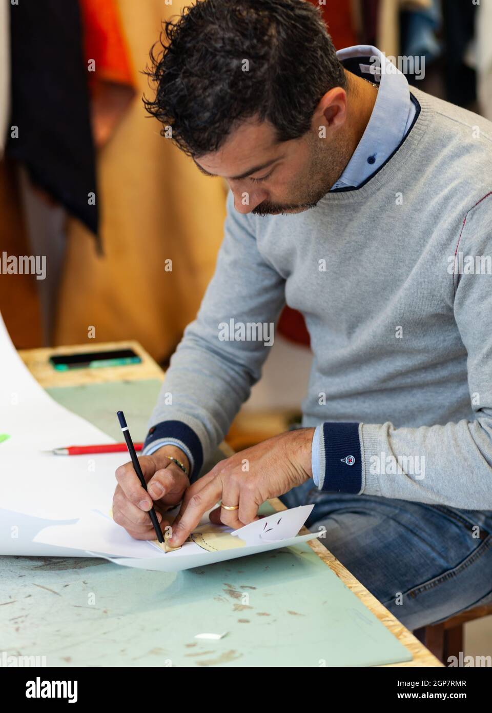 Shoemaker or shoe designer working with lwith paper models for leather ...