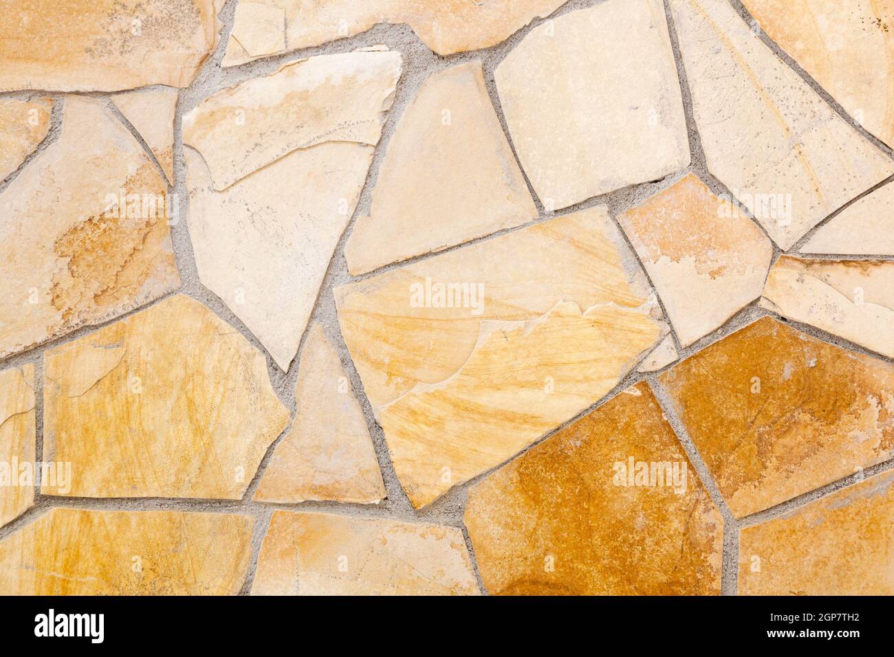 Wall lined with light yellow porphyry stones Stock Photo - Alamy