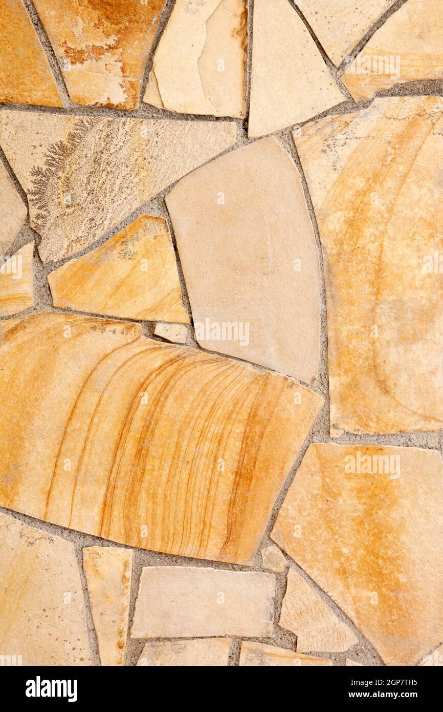 Wall lined with light yellow porphyry stones Stock Photo - Alamy