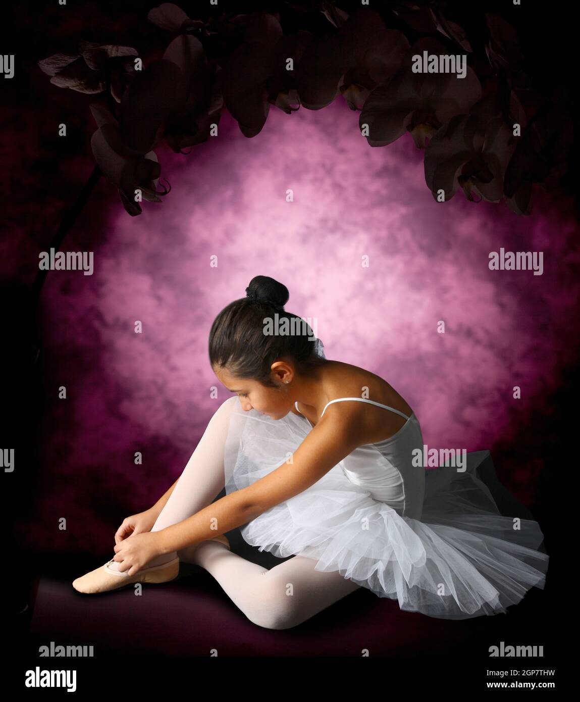 Ballerina tying ribbons pointe on purple background Stock Photo - Alamy