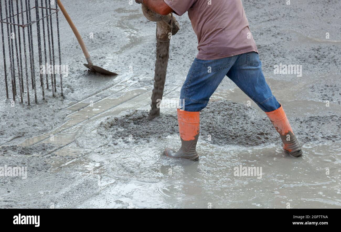 builder worker with tube from truck mounted concrete pump pouring ...