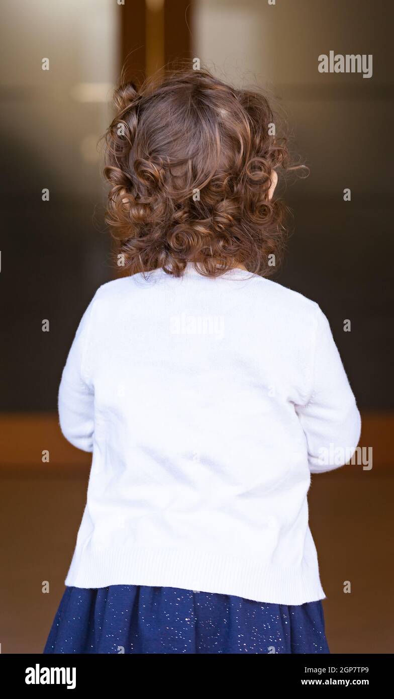 Beautiful baby girl from behind with curly hair Stock Photo - Alamy