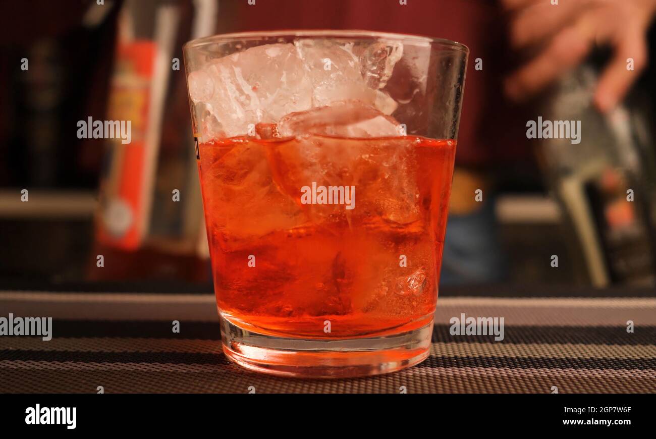 Bartender serves a Negroni cocktail on the bar counter Stock Photo - Alamy
