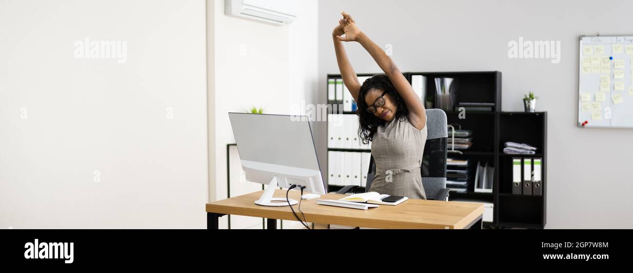 American African Doing Stretch Exercise At Work In Office Stock Photo ...