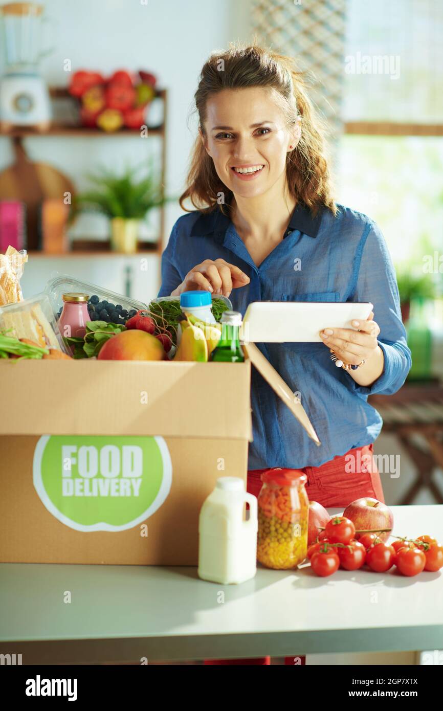 Food delivery. happy modern woman with food box using tablet PC app in ...