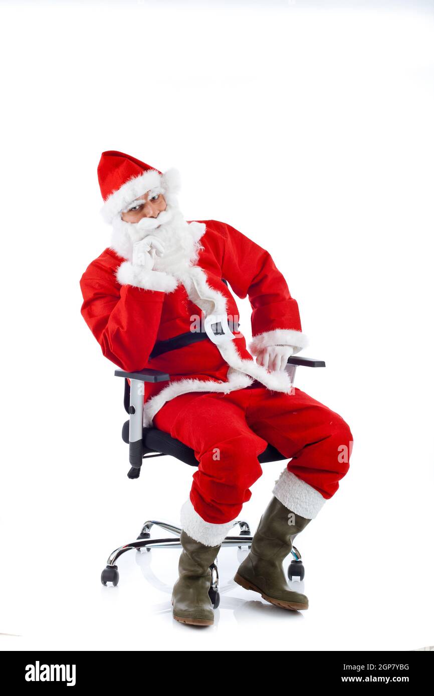 Young Santa Claus sitting on an office chair on white background Stock ...