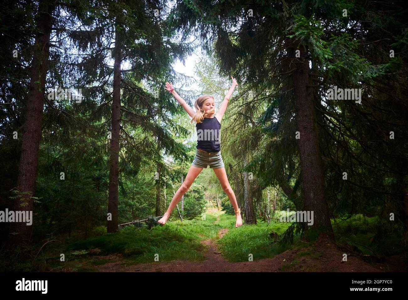Young girl flying in the air in the woods. Jumping for freedom Stock ...