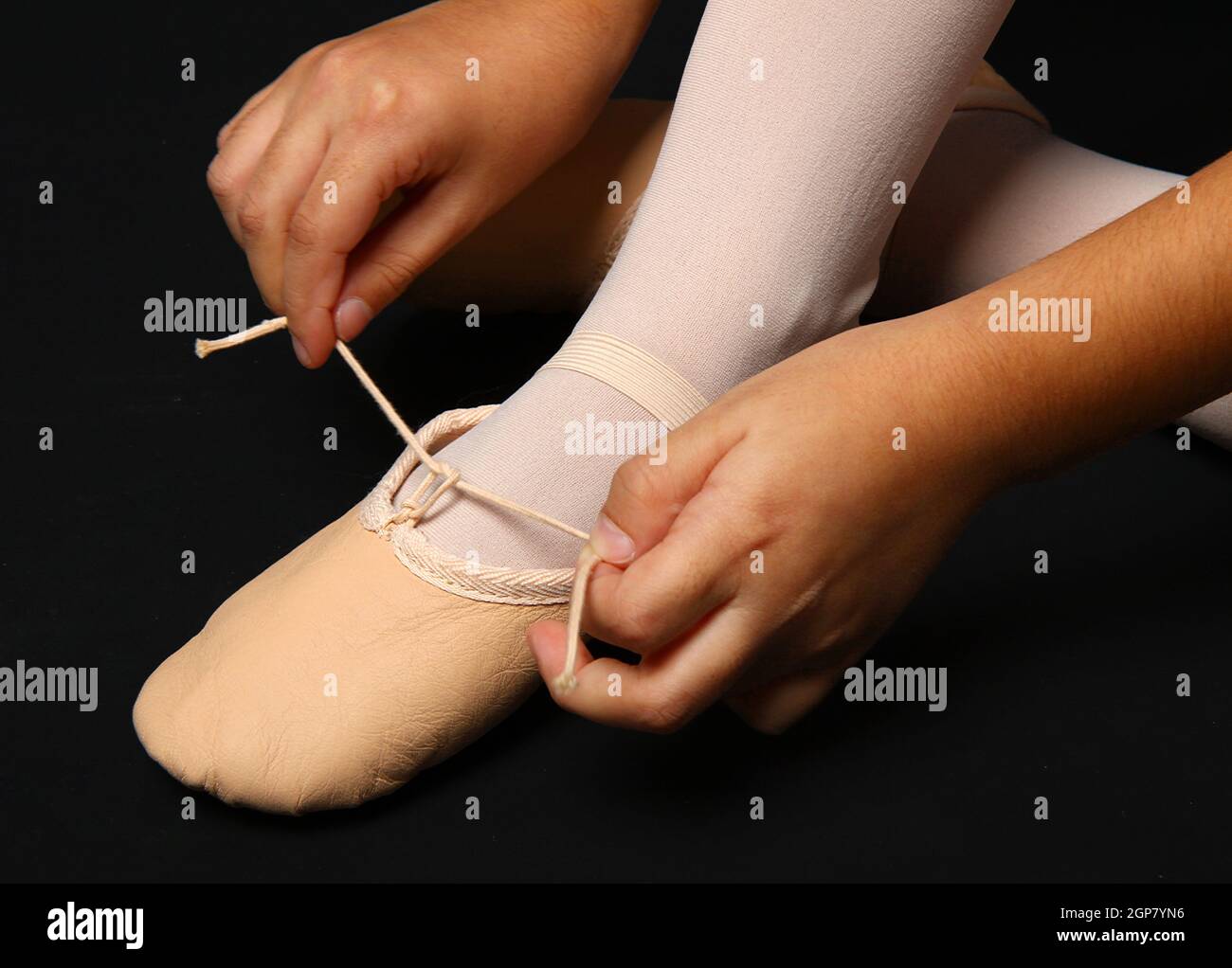 Detail of the feet of a dancer with demi-pointe on black background ...