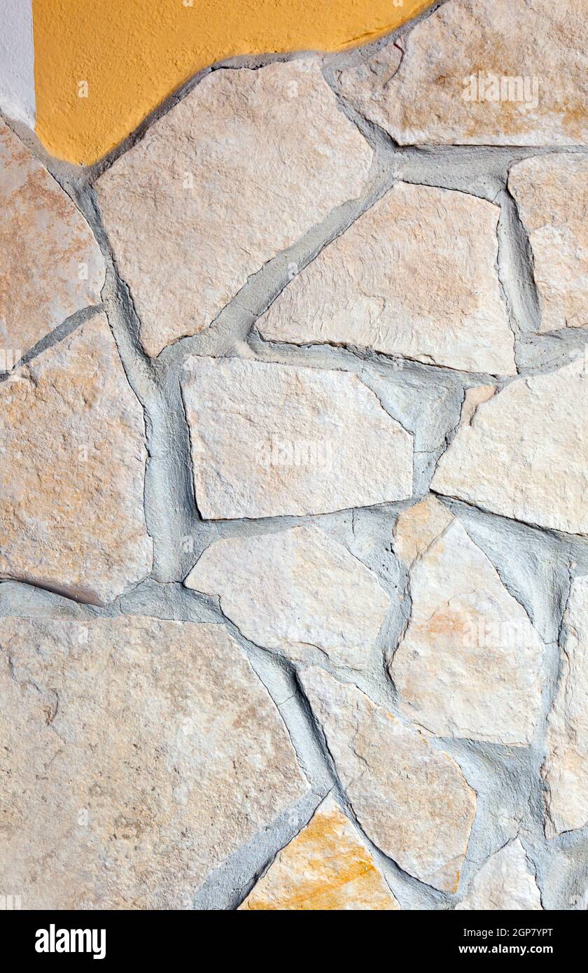 Wall lined with light yellow porphyry stones Stock Photo - Alamy