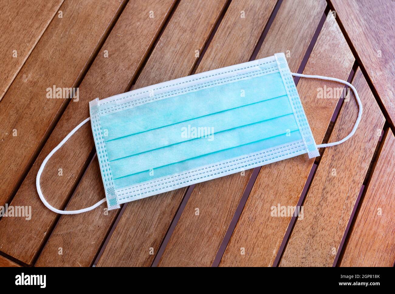 Face mask or surgical mask lays on wooden table with copy space ...