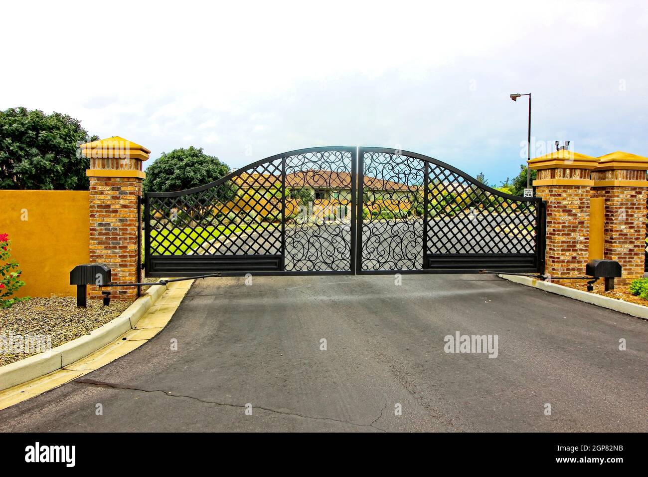 Electric Exit Metal Gate With Brick Columns Stock Photo - Alamy