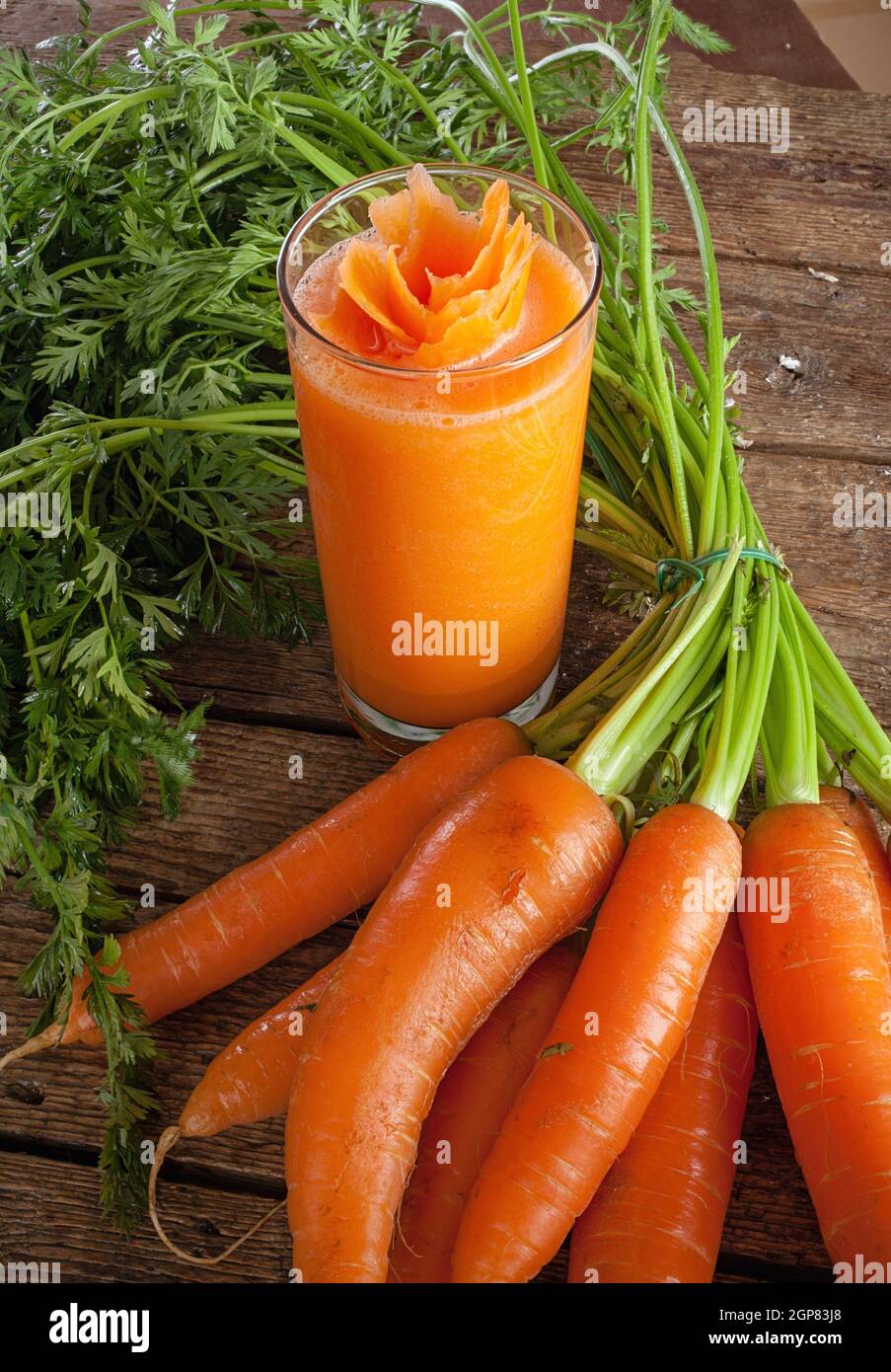 Fresh carrot juice glass with fresh organic carrots on wooden table ...