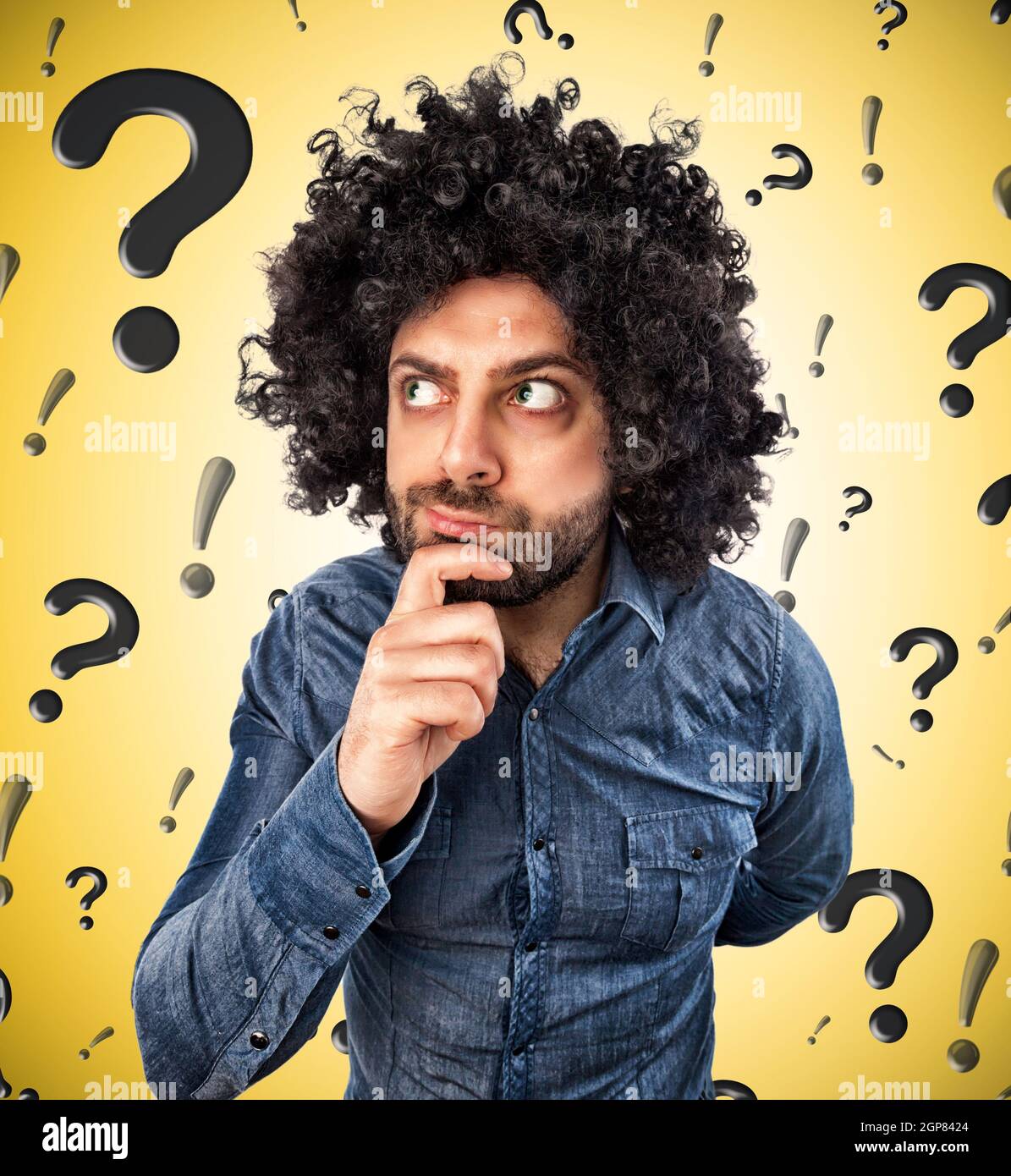 Young man thinks about something on background with question marks and ...