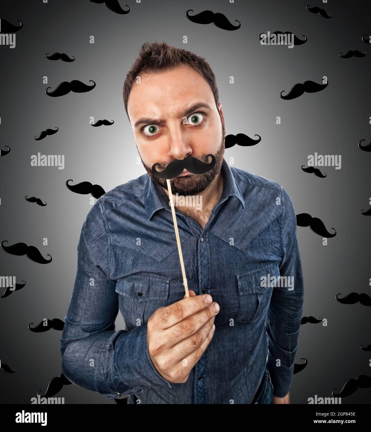 Young man with photo booth shaped mustache and background with small ...