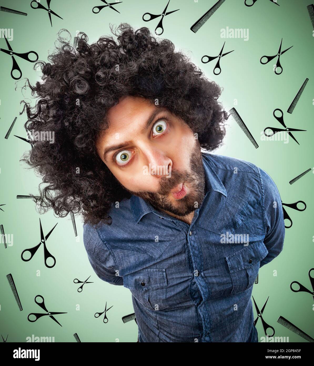 Young man with disheveled hair on background with scissors and combs ...