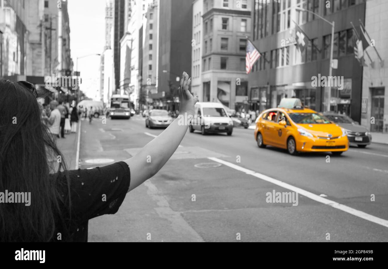 Tourist call a yellow cab in Manhattan with typical gesture with arm up ...