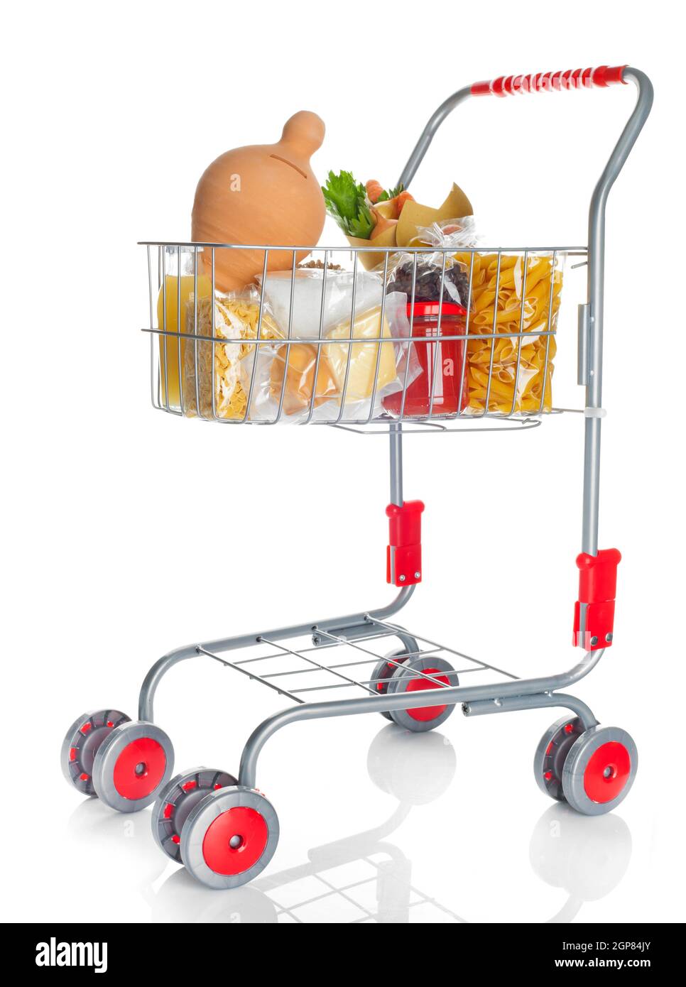Shopping cart full with money box and food products on white background ...