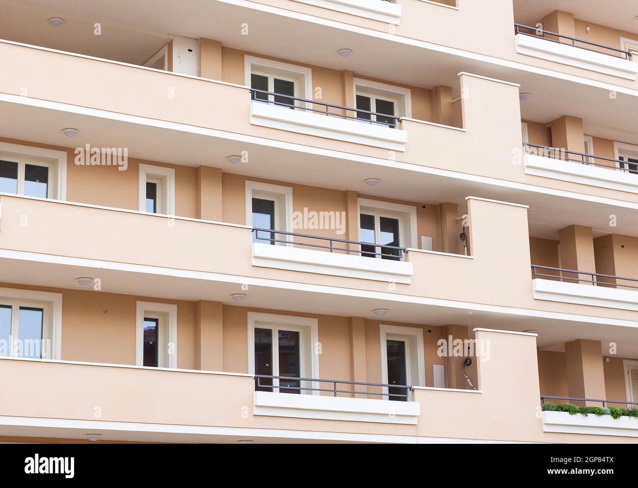 Pink facade of residential building with white windows Stock Photo - Alamy