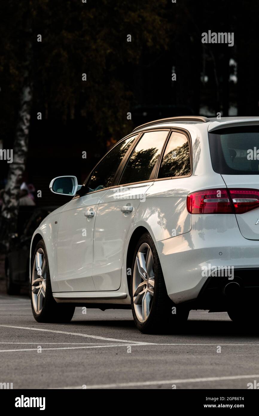 A side shot from behind of a white family sport car during sunset ...