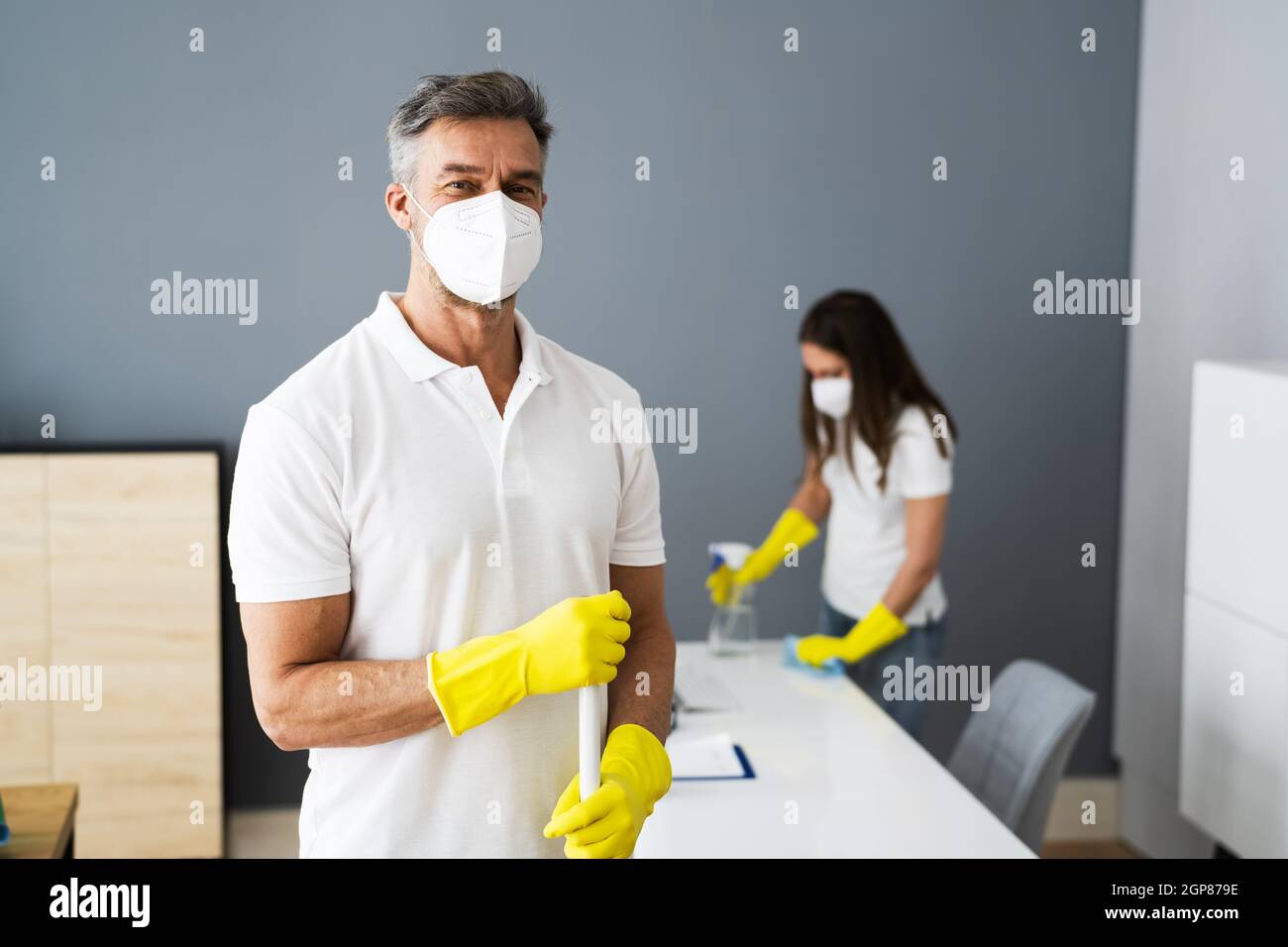 Cleaning Service Janitor Near Desk In Covid Face Mask Stock Photo - Alamy