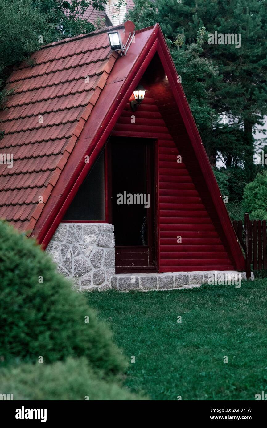 Triangle house in nature filled with woods and bushes Stock Photo - Alamy