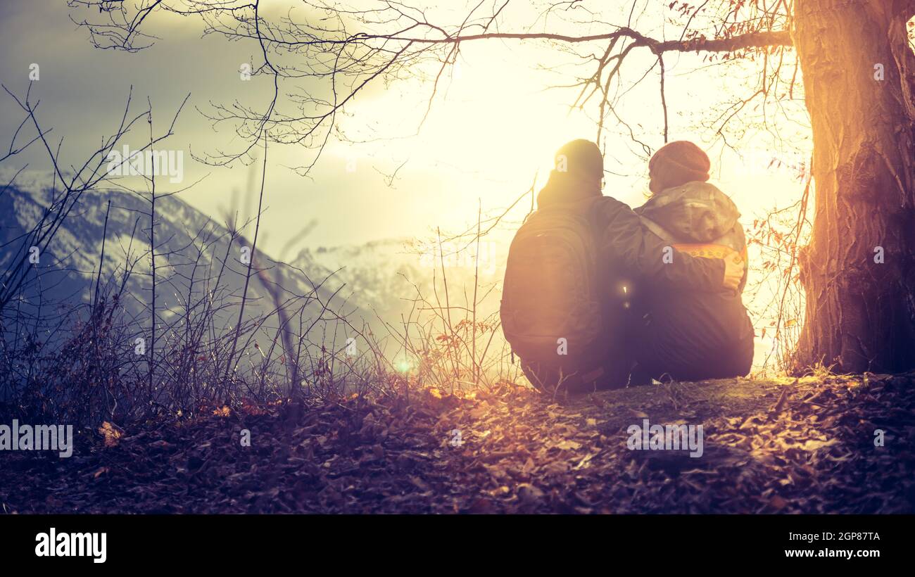 Loving couple enjoys the mountain view, beautiful scenery with sundown ...