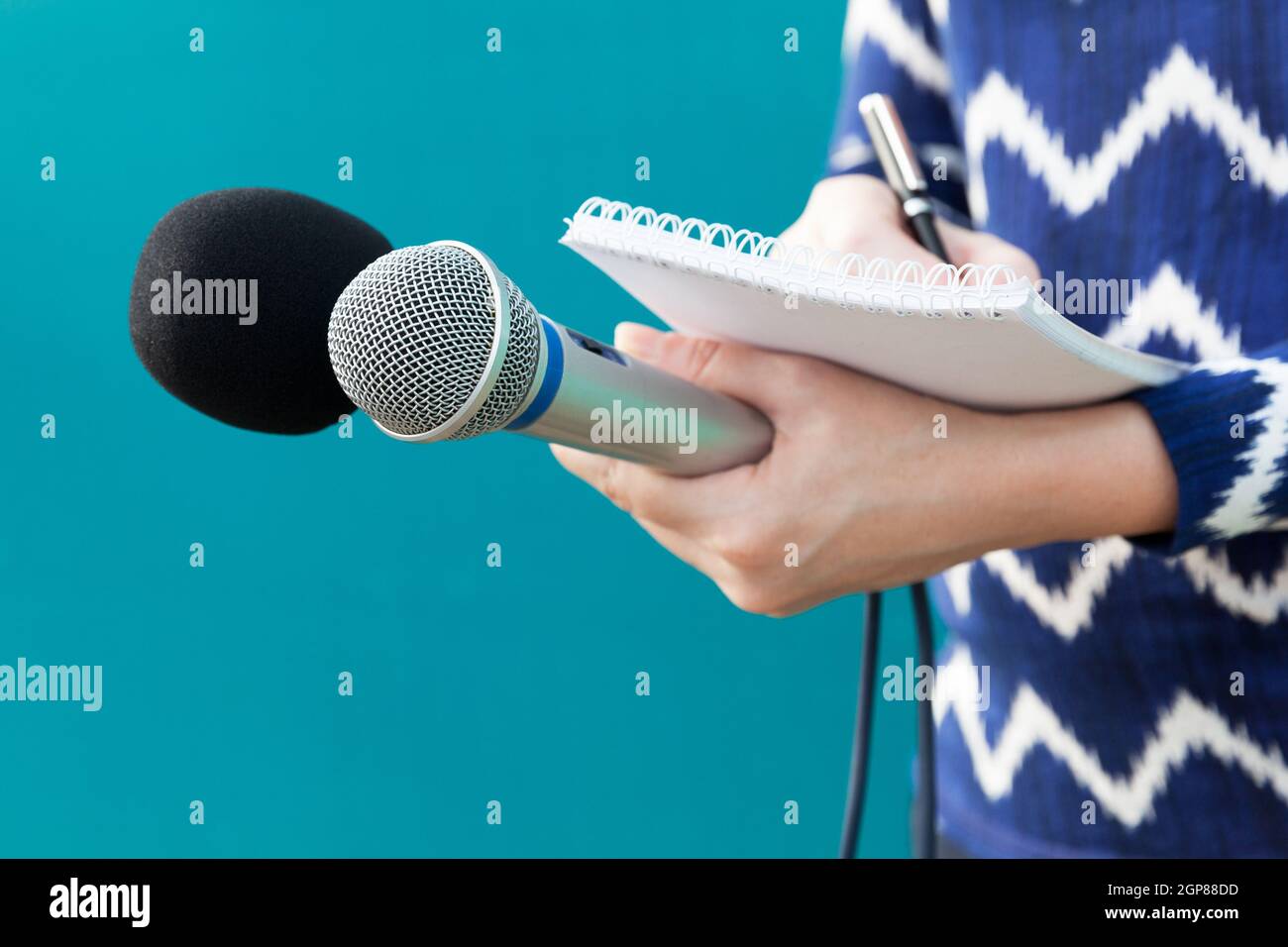 Female reporter or journalist at news conference, holding microphone ...