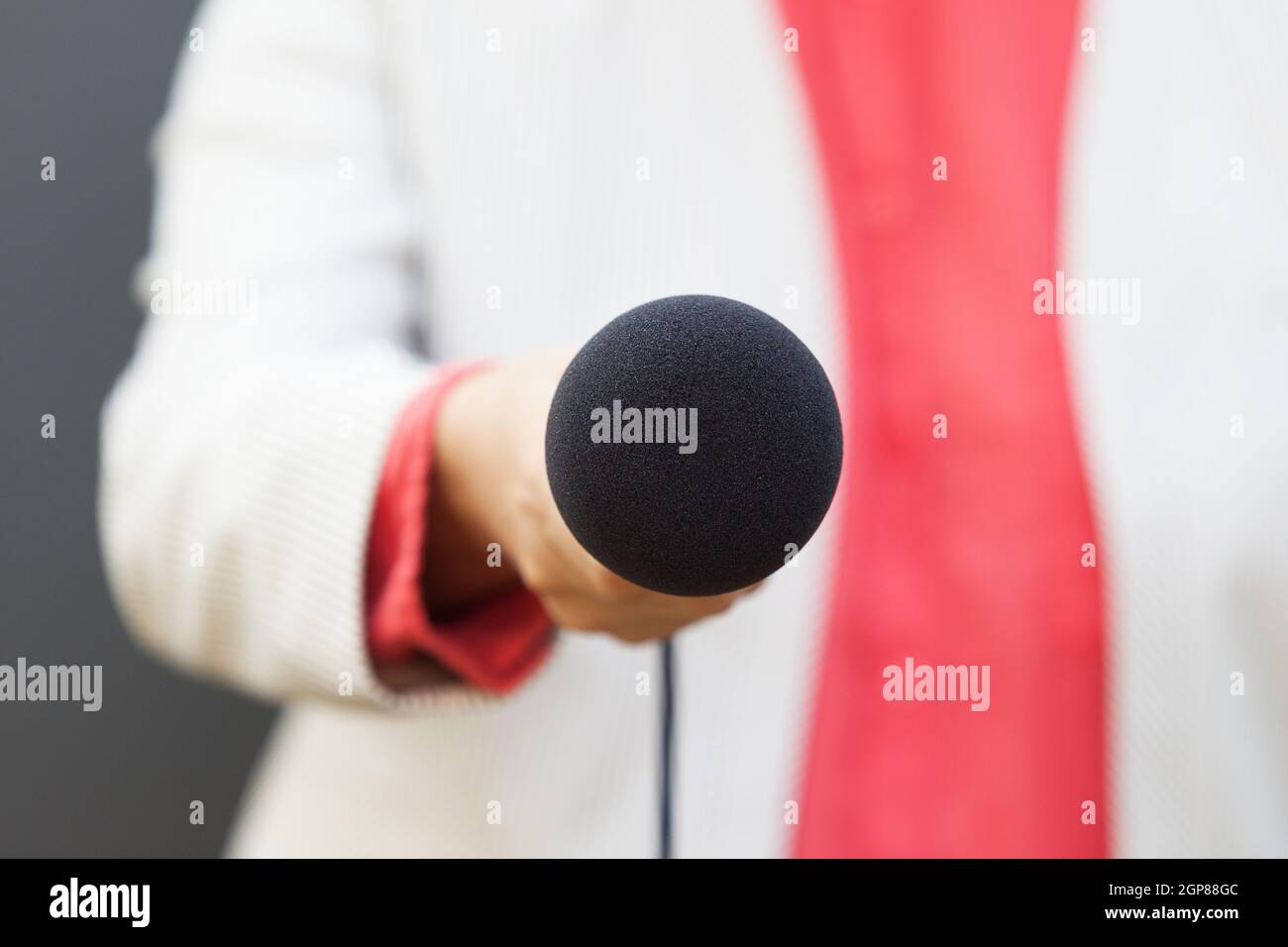 Female reporter holding microphone during media interview. Journalism ...