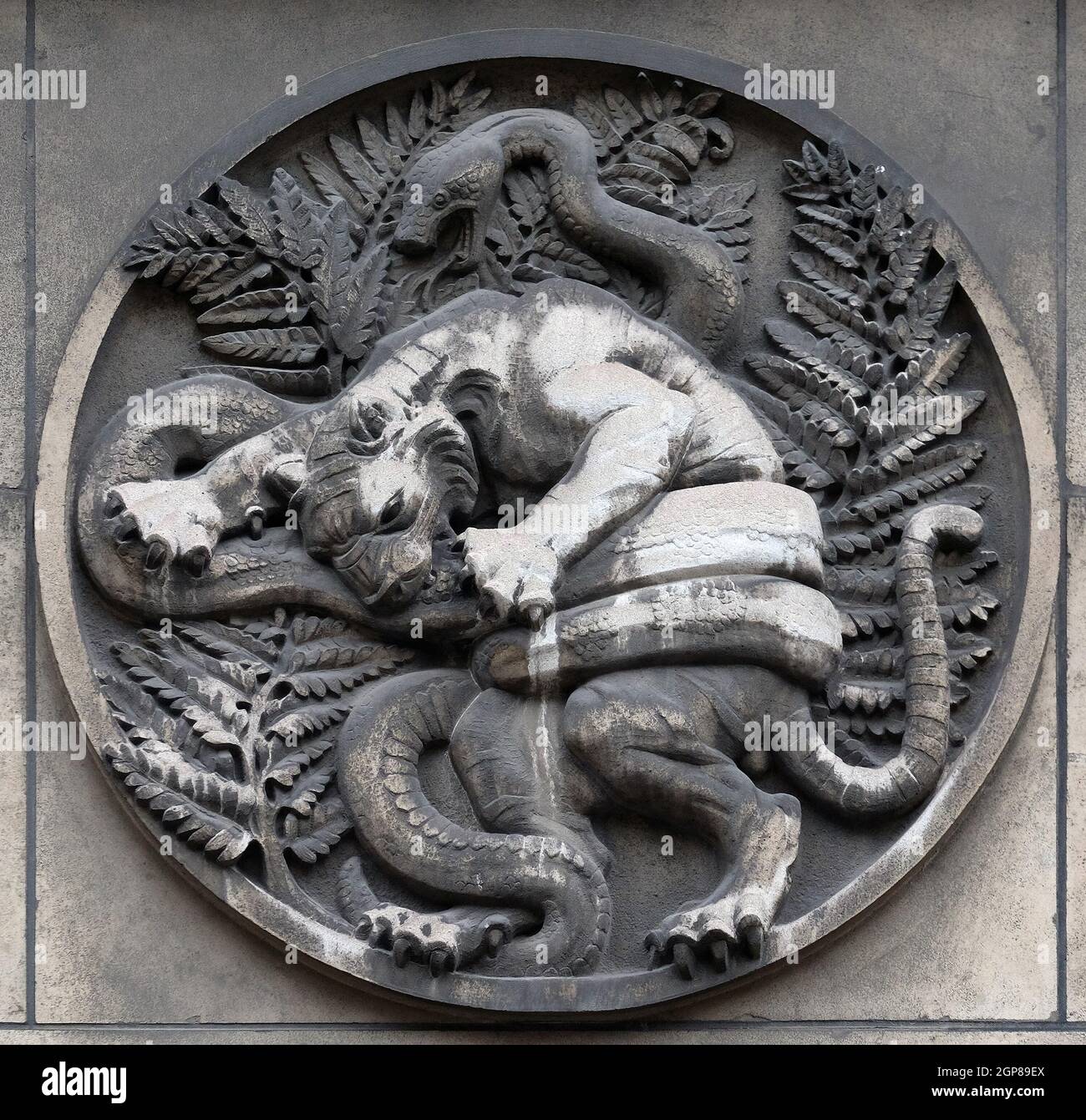 Lion and snake. Stone relief at the building of the Faculte de Medicine ...
