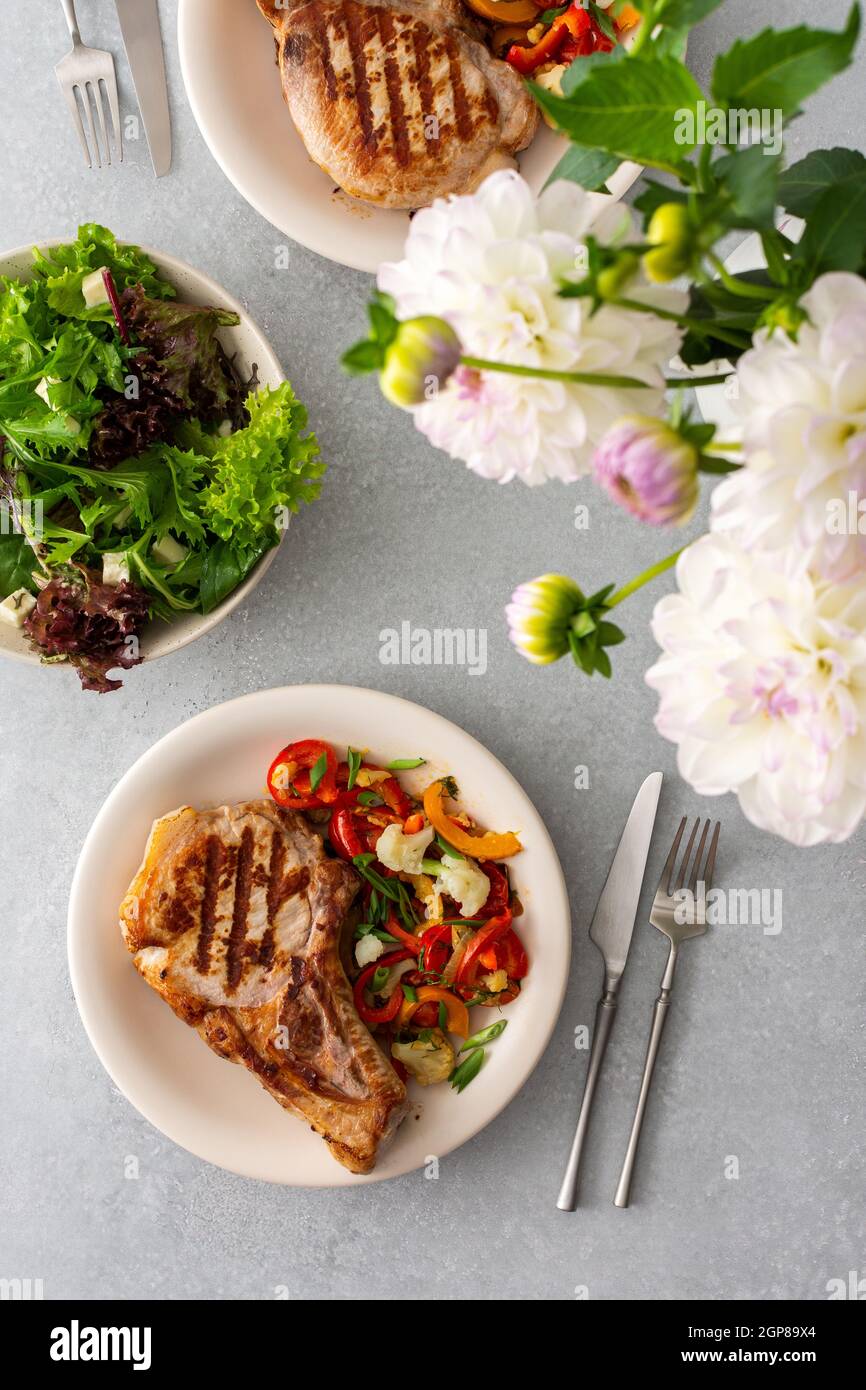 Delicious hearty dinner in plates on the table and a bouquet of ...