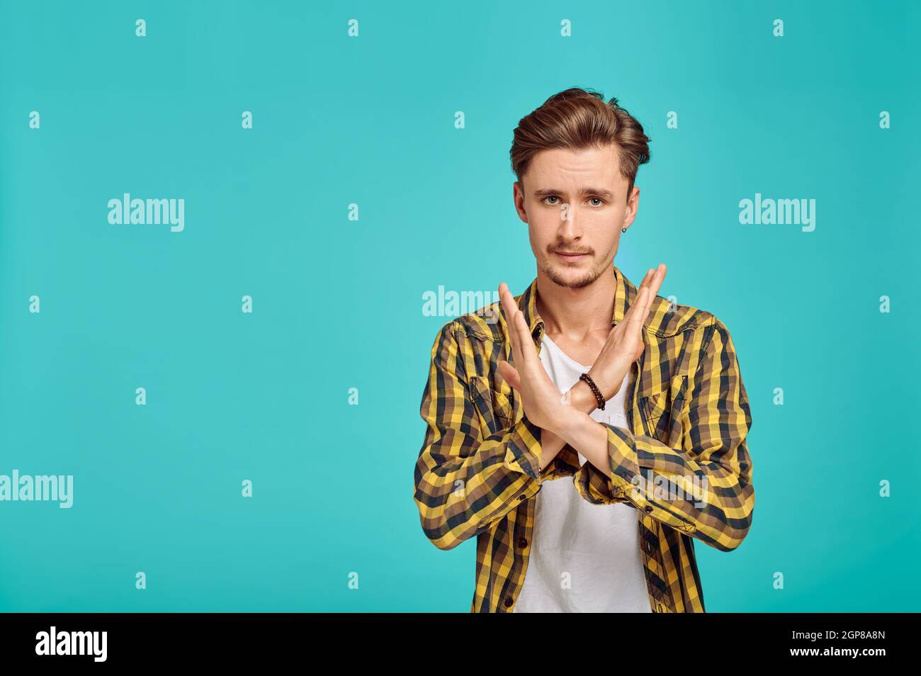 Serious man with crossed hands, blue background, emotion. Face ...