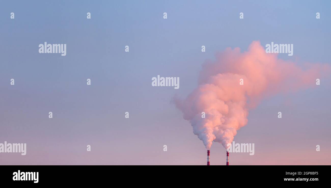 Smoke from chimneys of heating plant. Air pollution. Factory pipes with ...