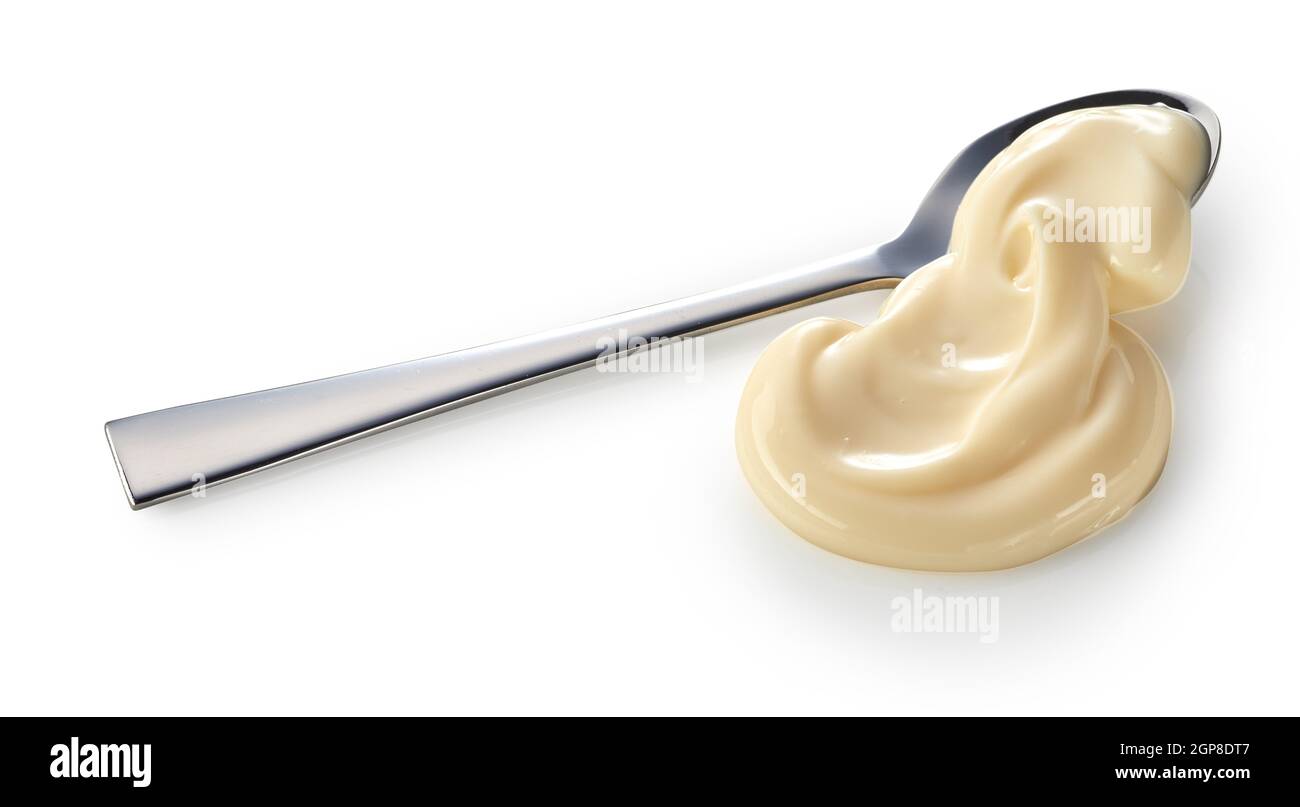 Spoonful of creamy homemade mayonnaise spilling onto a white background ...