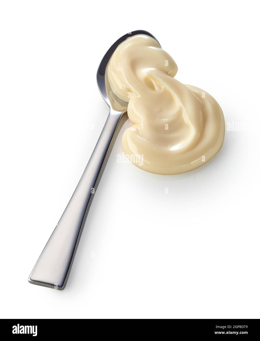 Creamy mayonnaise spilling from a spoon in a decorative swirl for use ...