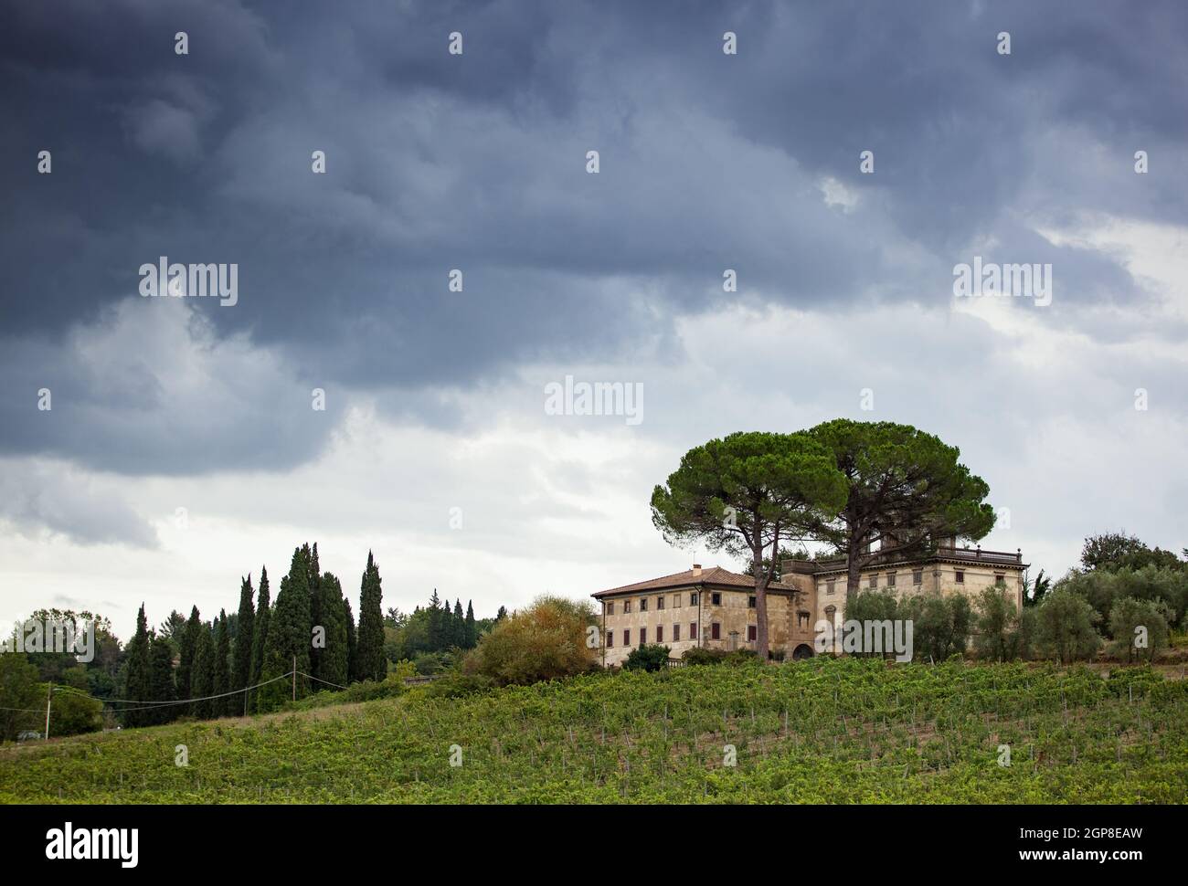 Tuscan hillside panorama with cloudy sky and typical local habitation ...