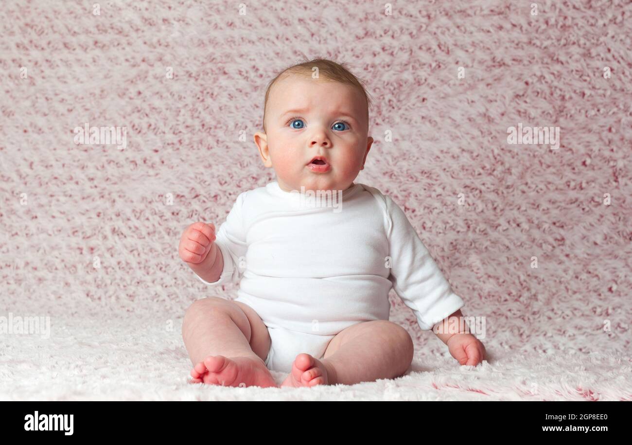 Sitting newborn baby girl with white bodysuit on blanket Stock Photo ...