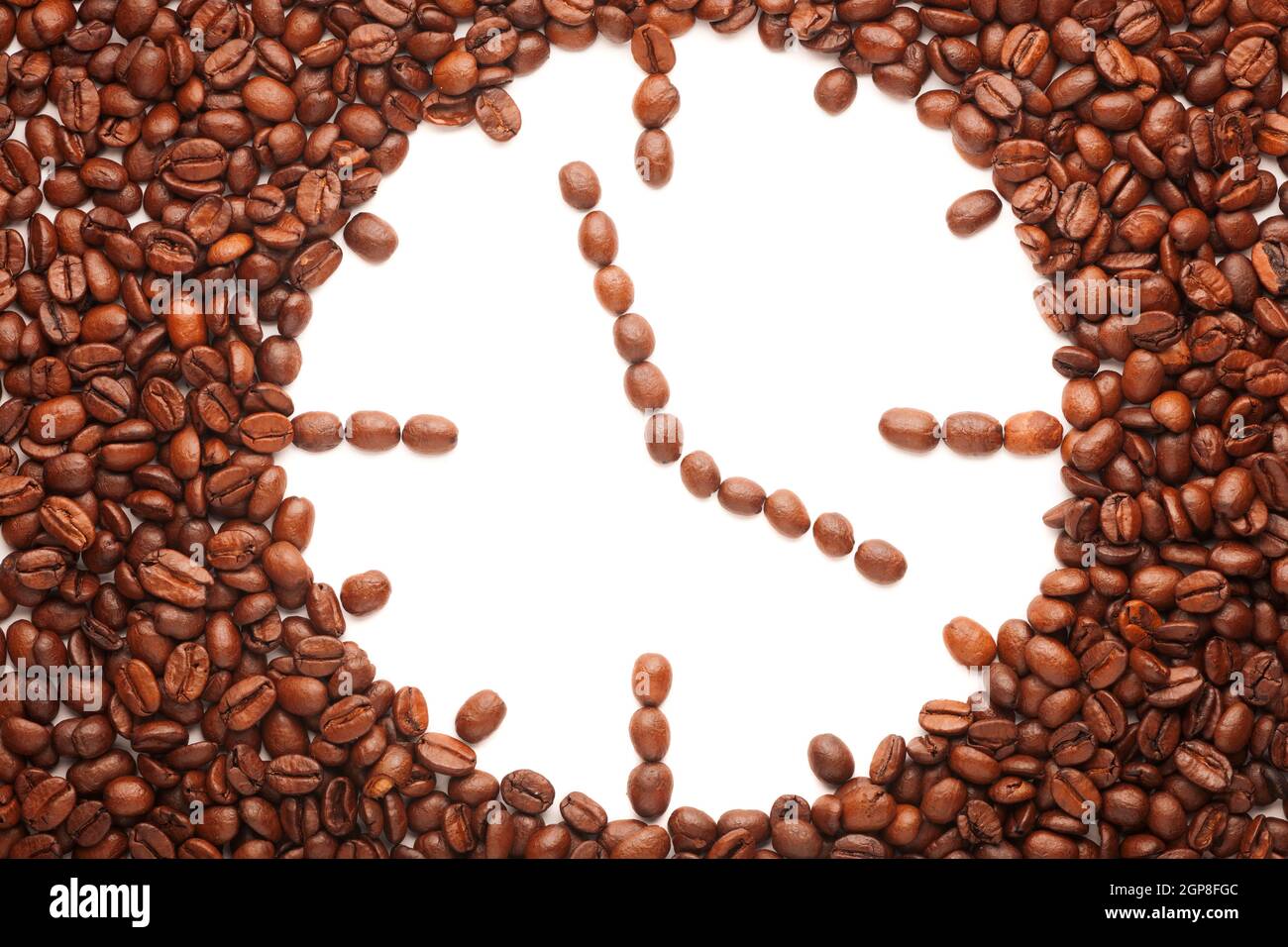 Roasted coffee beans surround a white surface in the form of a round ...
