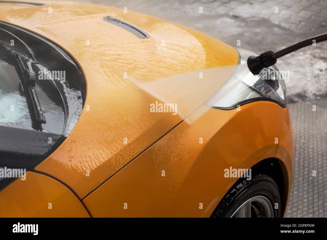 Yellow car front washed by water jet spray in carwash Stock Photo - Alamy