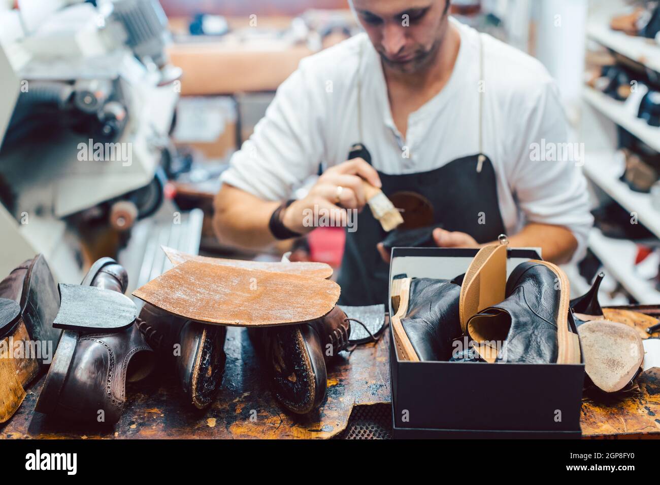 Shoemaker putting glue on sole of a shoe to fix Stock Photo - Alamy
