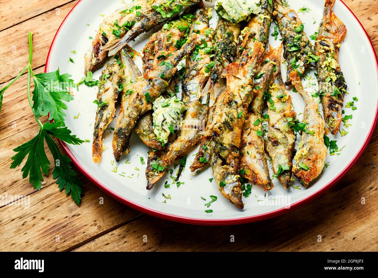 Roasted capelin fish with herbs.Fried capelin fish on plate Stock Photo ...