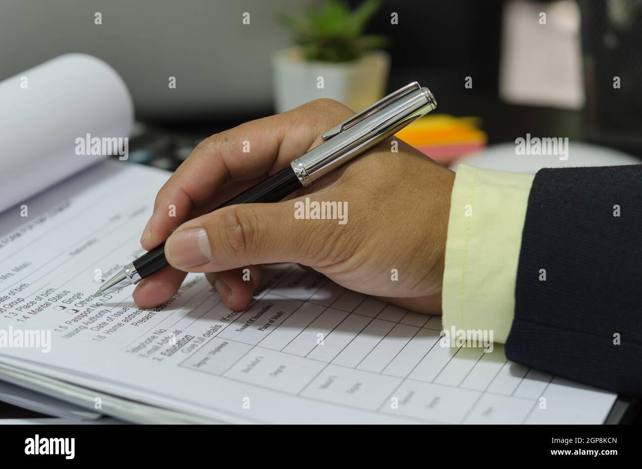 Hand with pen write application documents on desk Stock Photo - Alamy