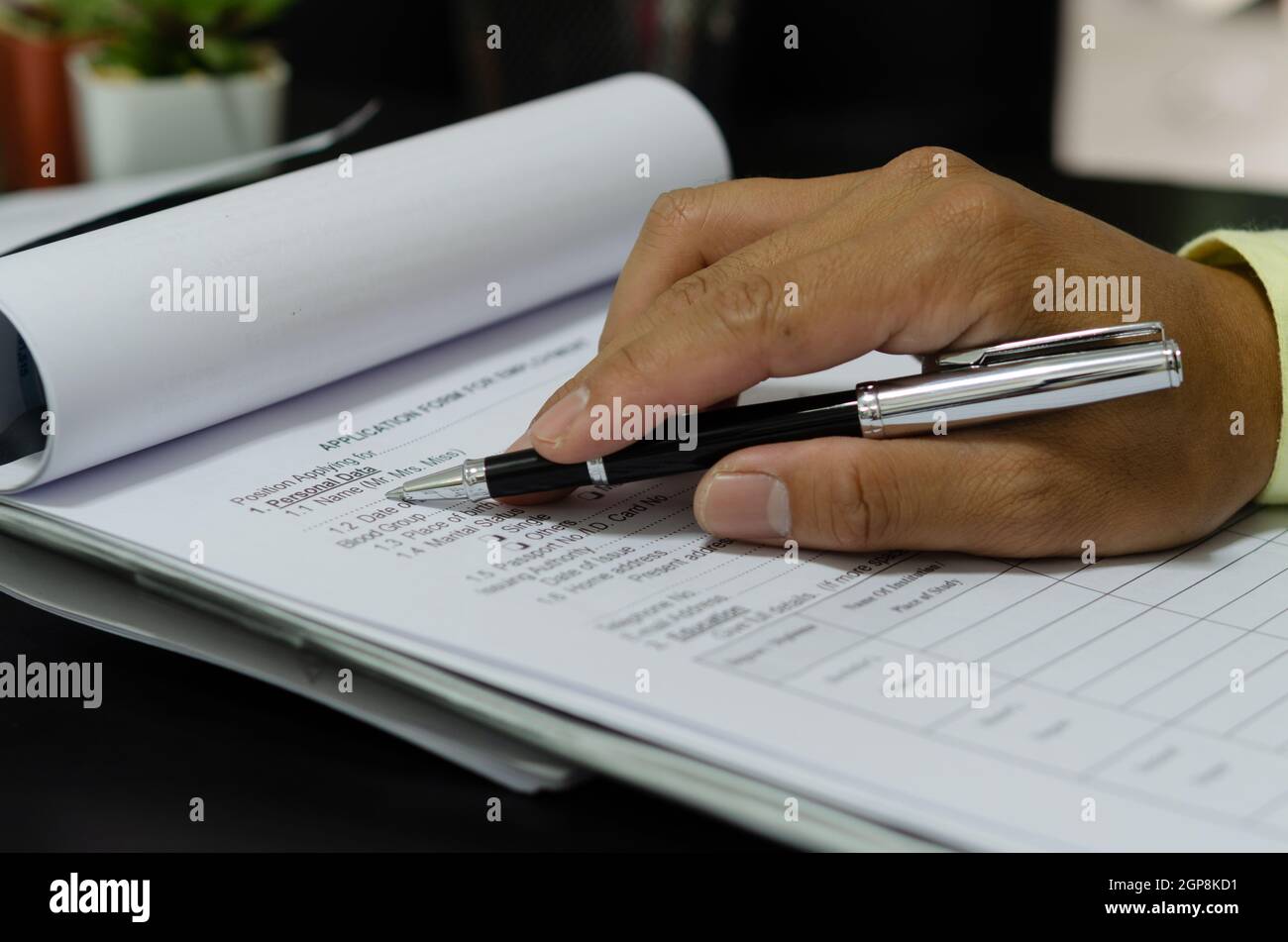 Hand with pen write application documents on desk Stock Photo - Alamy