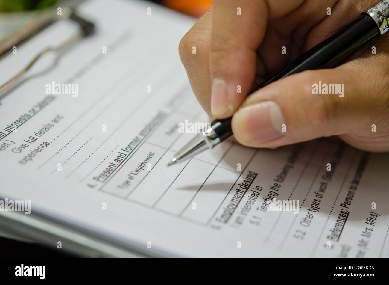 Hand with pen write application documents on desk Stock Photo - Alamy