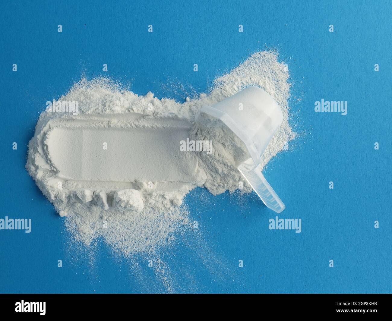 Measuring spoon with protein powder on a blue background, nutritional ...